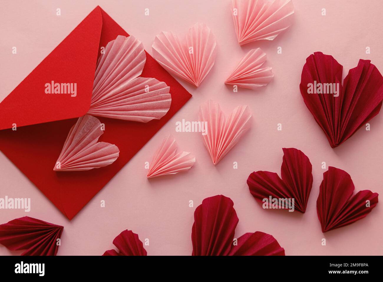 Happy Valentine's day! Stylish pink hearts and red envelope flat lay on ...