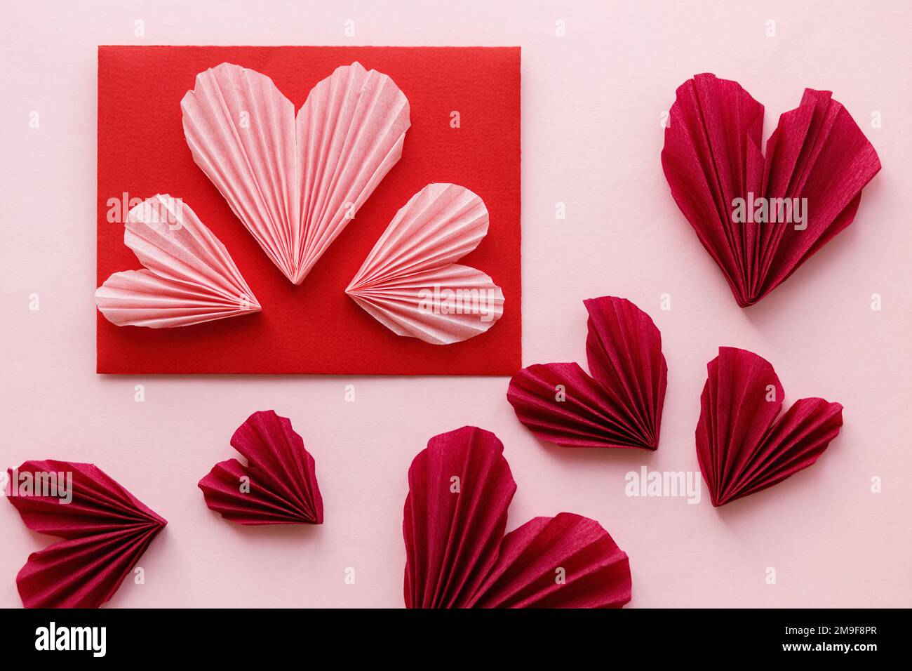 Happy Valentine's day! Stylish pink hearts and red envelope flat lay on ...