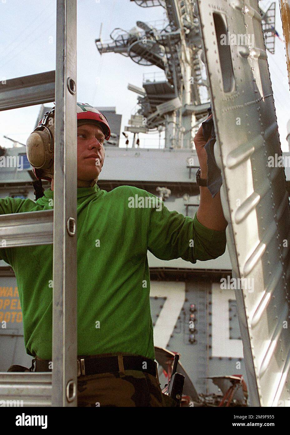 US Navy Aviation Ordnanceman Jason Huval wipes down the stabilizer on a ...