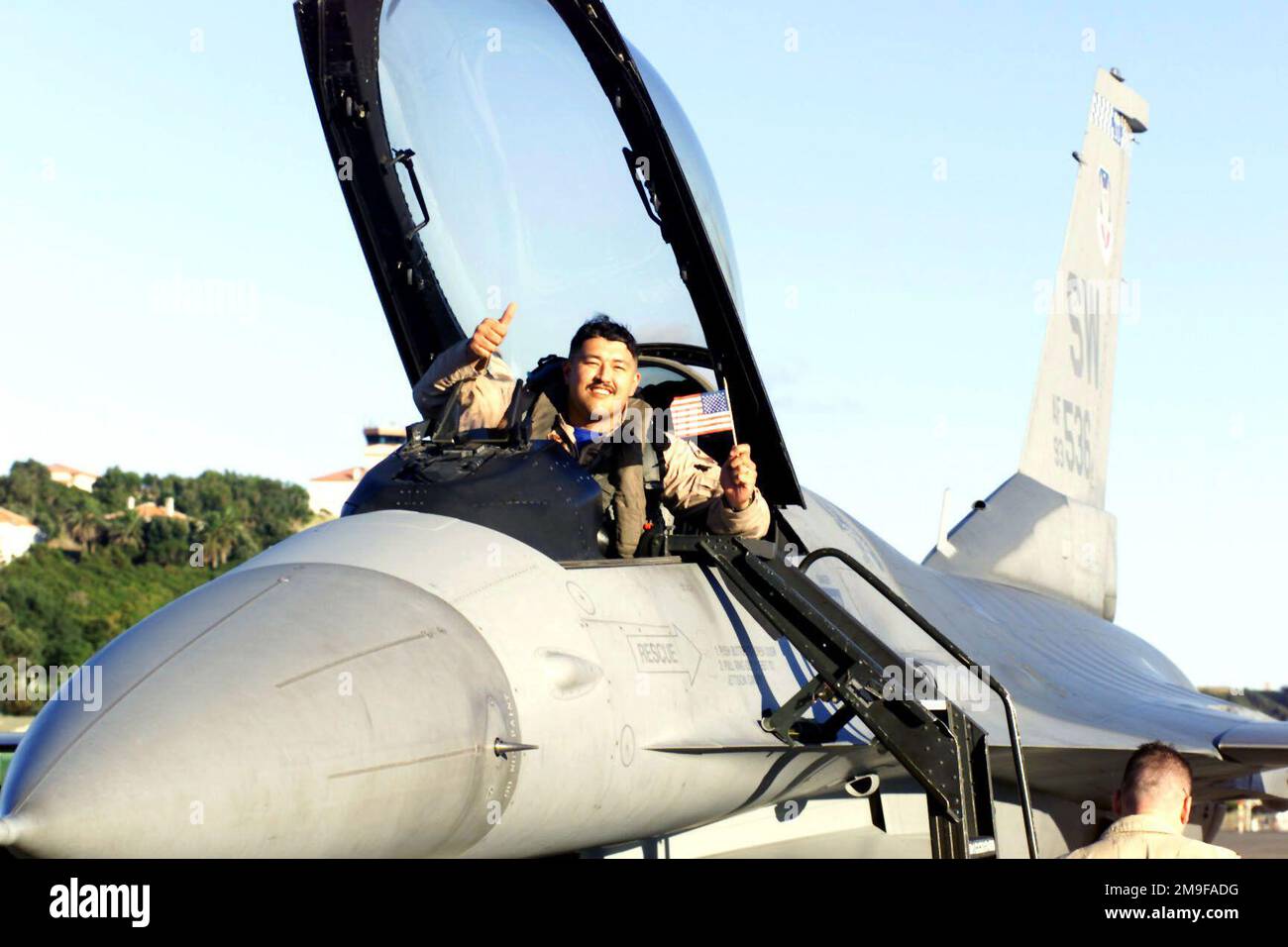 US Air Force Captain Tony Meyer holds an American flag after landing at ...