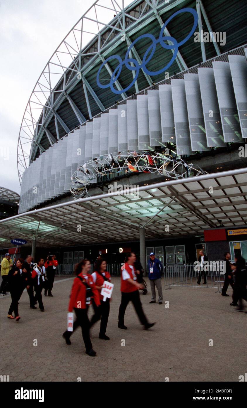 Visitors to the Sydney 2000 Olympics pass under the Olympic rings ...
