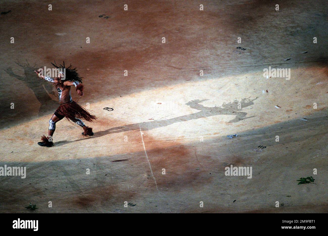 An Aboriginal dancer makes his way across the floor of the Olympic ...