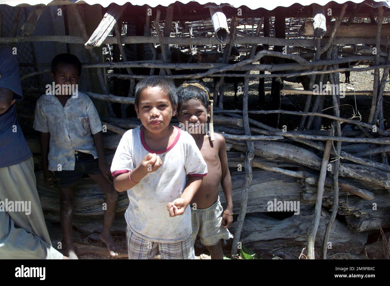 Local Children pose for a photograph while they take cover from the sun ...