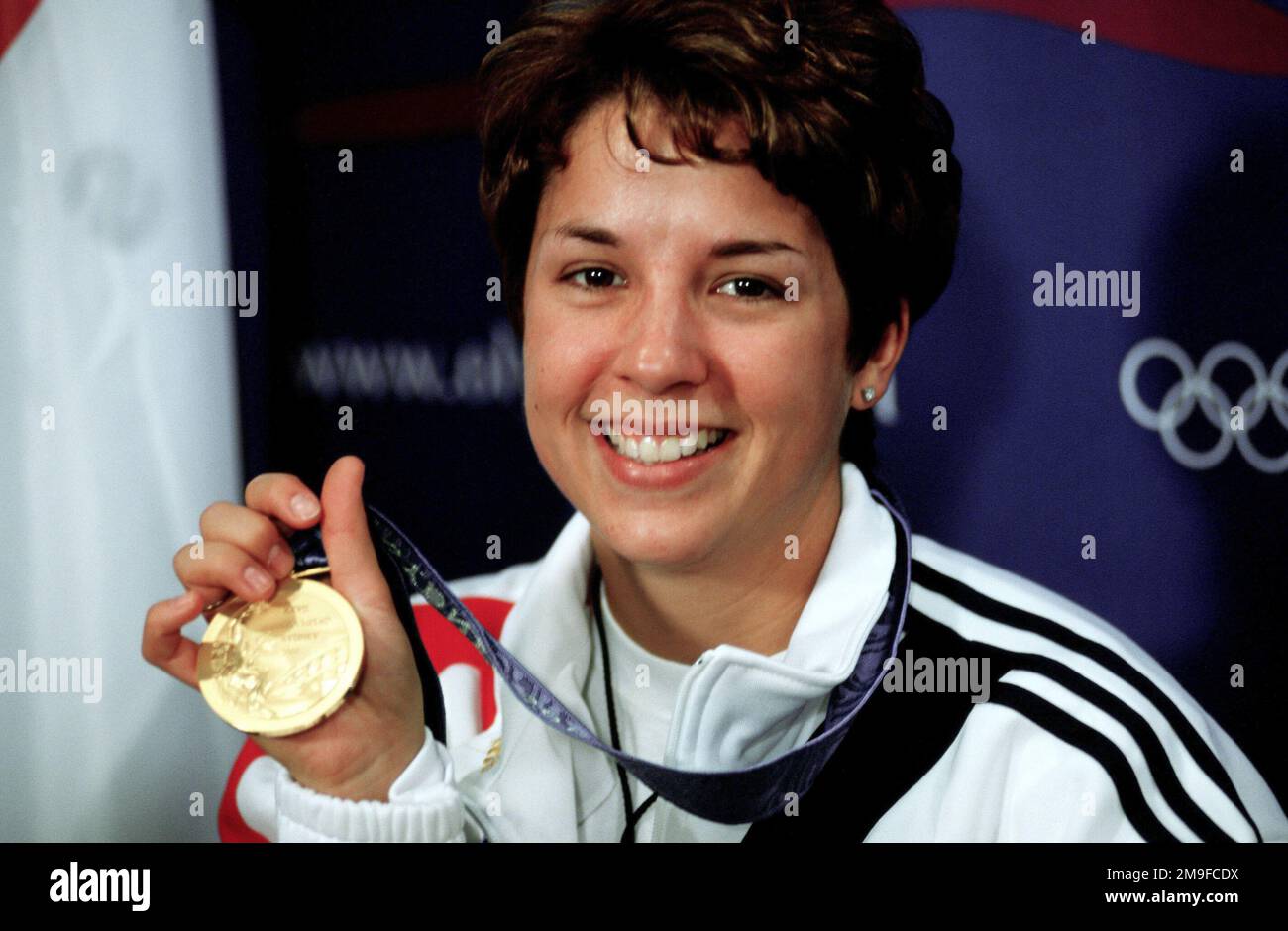 Nancy Johnson holds up the gold medal she won in the 10-Meter Air Rifle ...