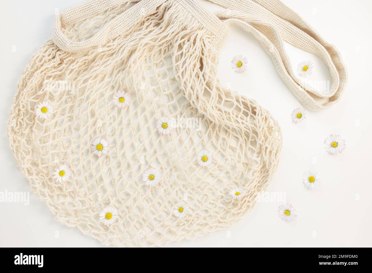 Reusable shopping mesh bag on white with flowers background. Zero waste ...