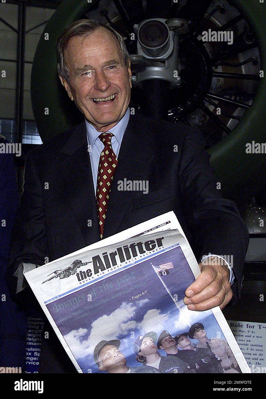 Former US President George Bush takes a minute to thumb through the ...