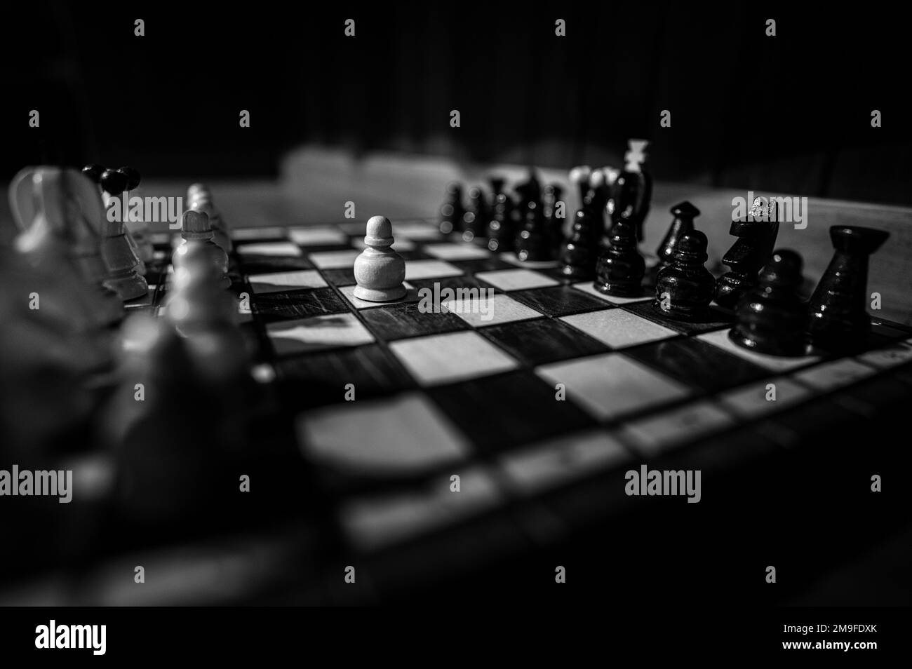 The set of wooden chess pieces elements standing on chess board on dark ...