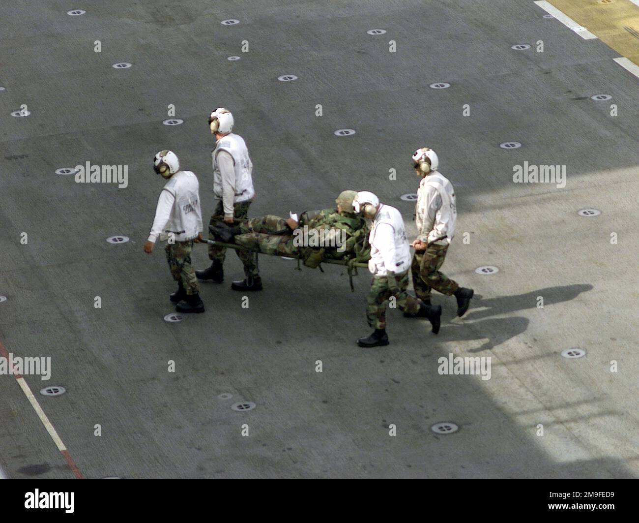 US Marines from Combat Cargo aboard the USS Essex (LHD 2), carry a ...