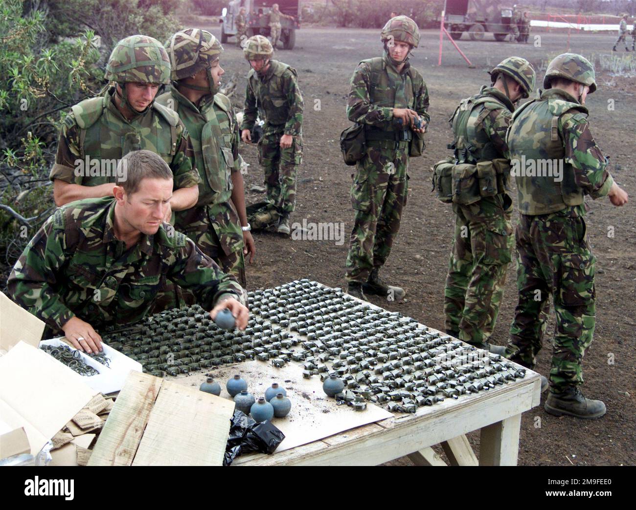 British Royal Marine Corporal Millward passes out dummy grenades to his ...