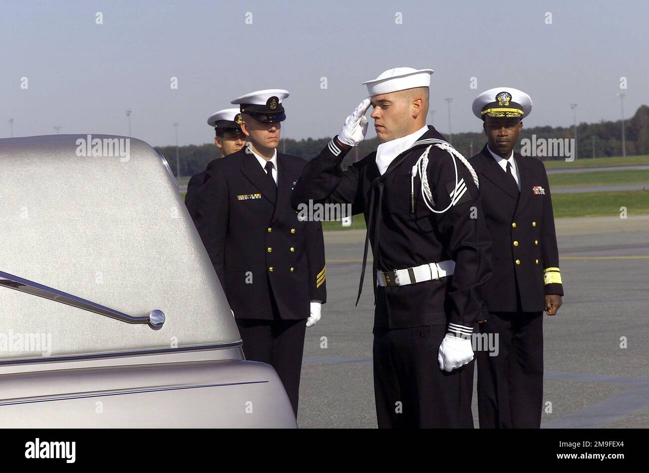 A member of the United States Navy Ceremonial Guard salutes the remains ...