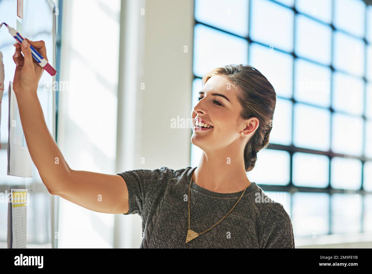 Woman, writing and board for presentation, vision or brainstorming for idea, goals and strategy ...