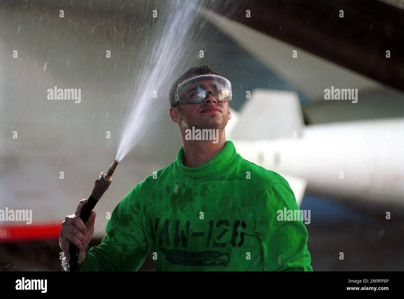 US Navy Aviation Electronics Technician Josiah Gross rinses soap of the ...
