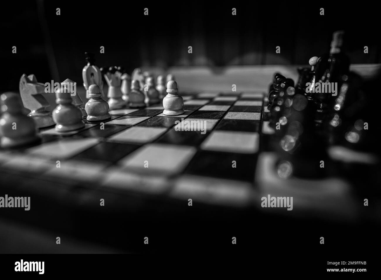 The set of wooden chess pieces elements standing on chess board on dark ...