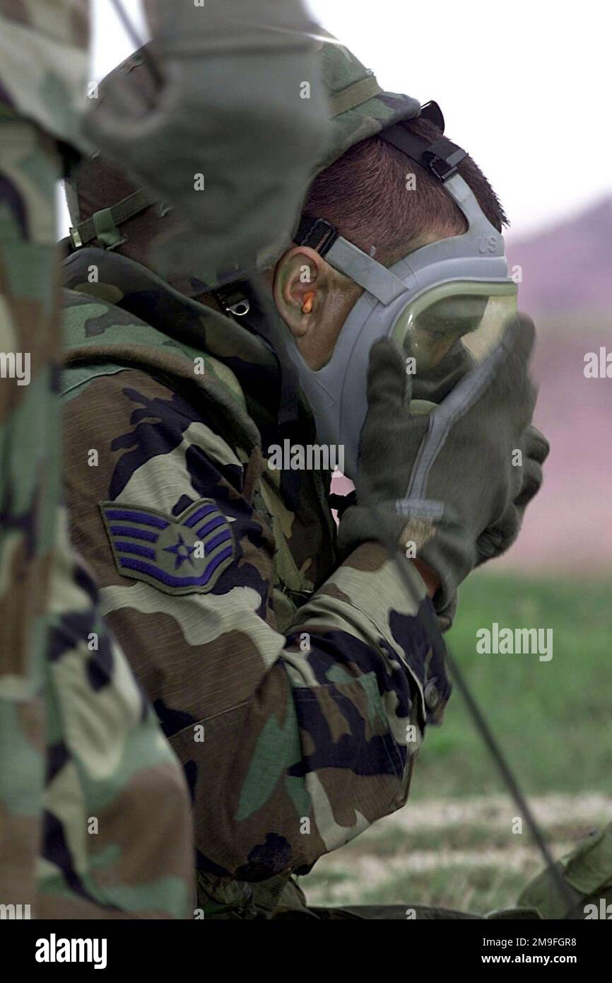 US Air Force STAFF Sergeant Timothy J. Arnold, Air Mobility Command team, puts on his gas mask ...