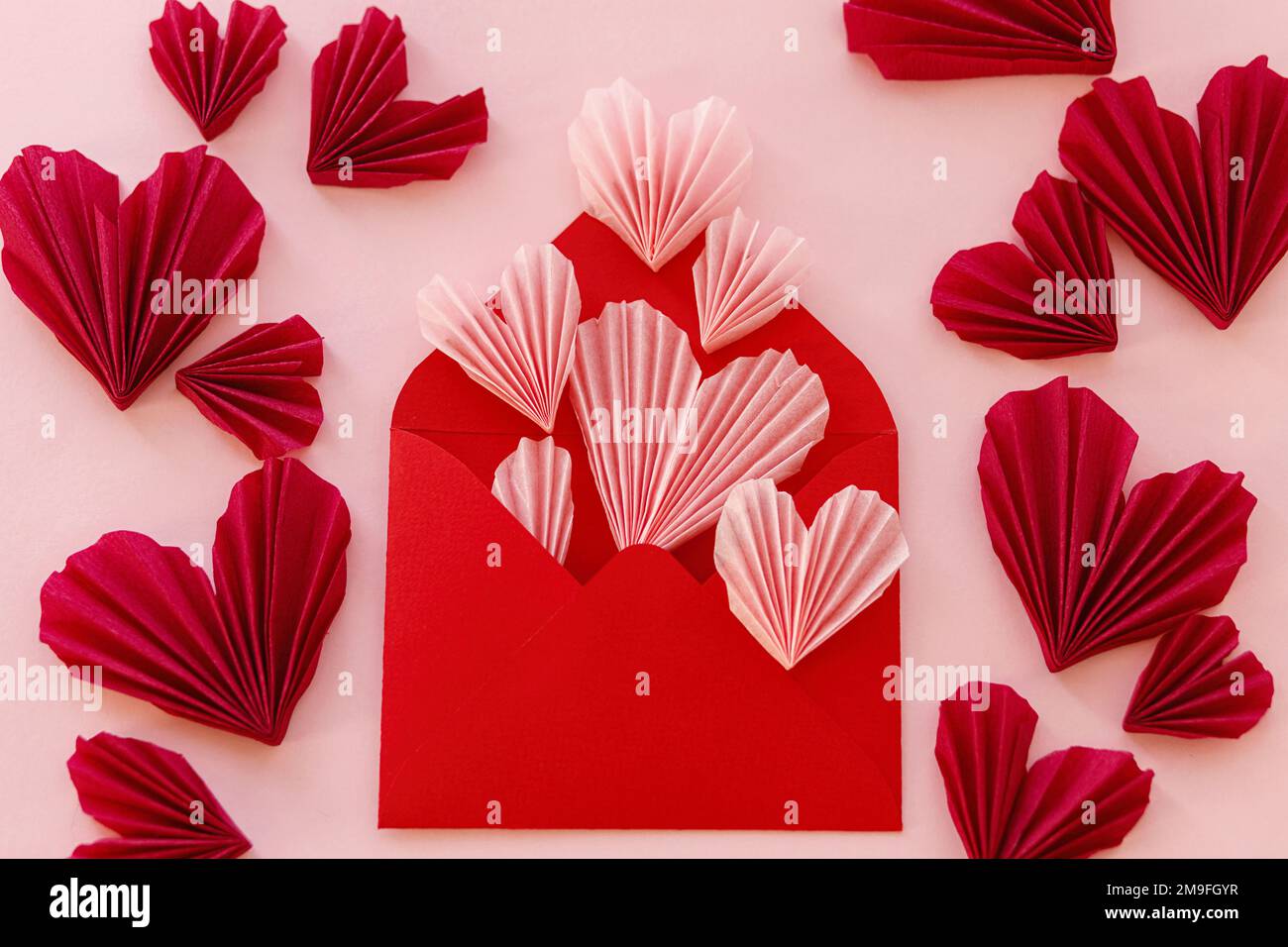 Valentines day flat lay. Stylish envelope with pink and red hearts ...
