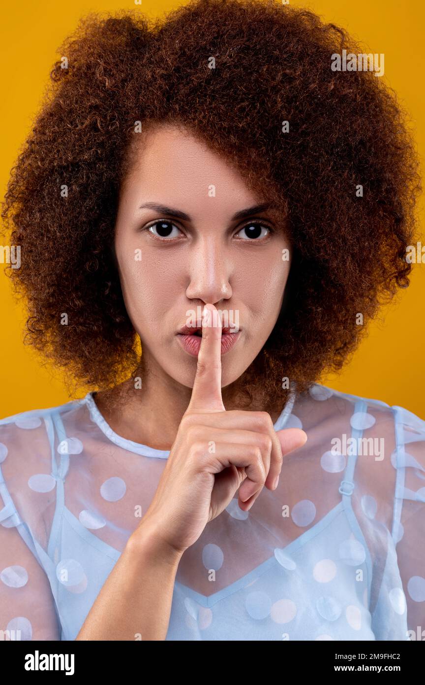 Pretty young woman showing a hush sign Stock Photo - Alamy