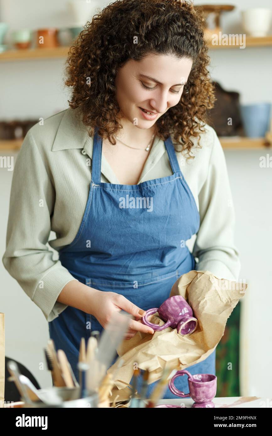 Happy entrepreneur sells dishes, plates and cups made of clay, ceramics ...
