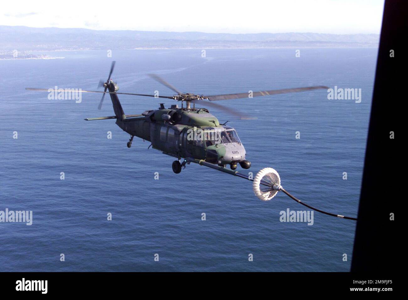 An HH-60G Pavehawk helicopter plugs into the air refueling hose from an ...