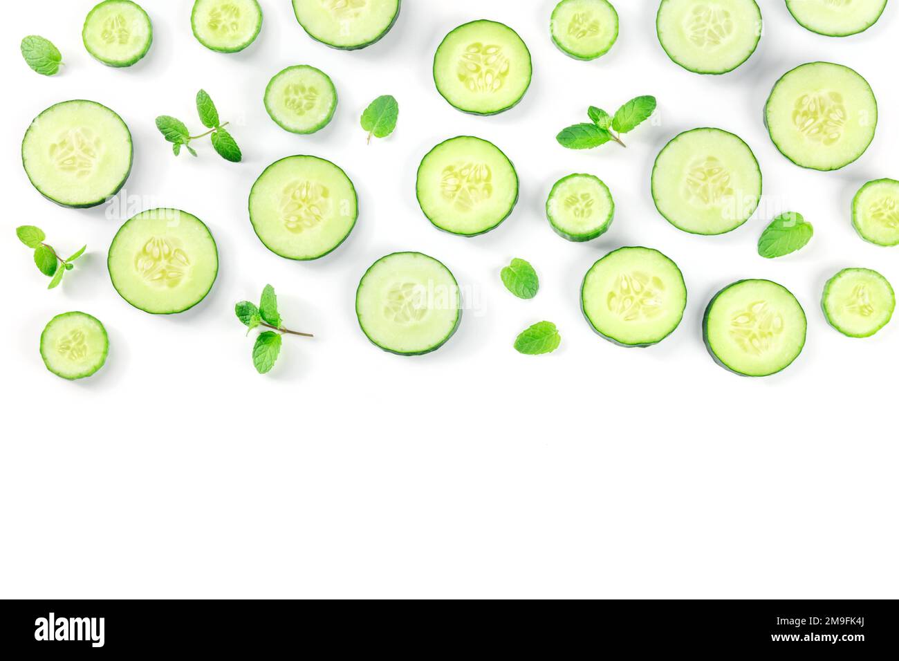 Fresh cucumber slices and mint leaves on a white background with copy ...