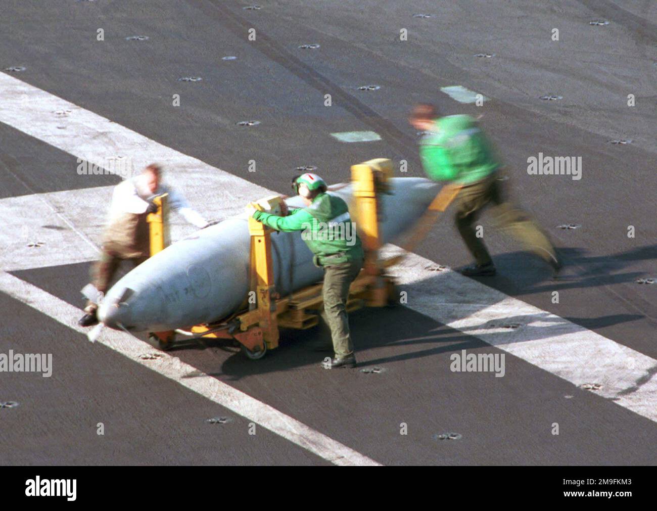 Crew members move a fuel pod on the flight deck of USS HARRY S. TRUMAN ...