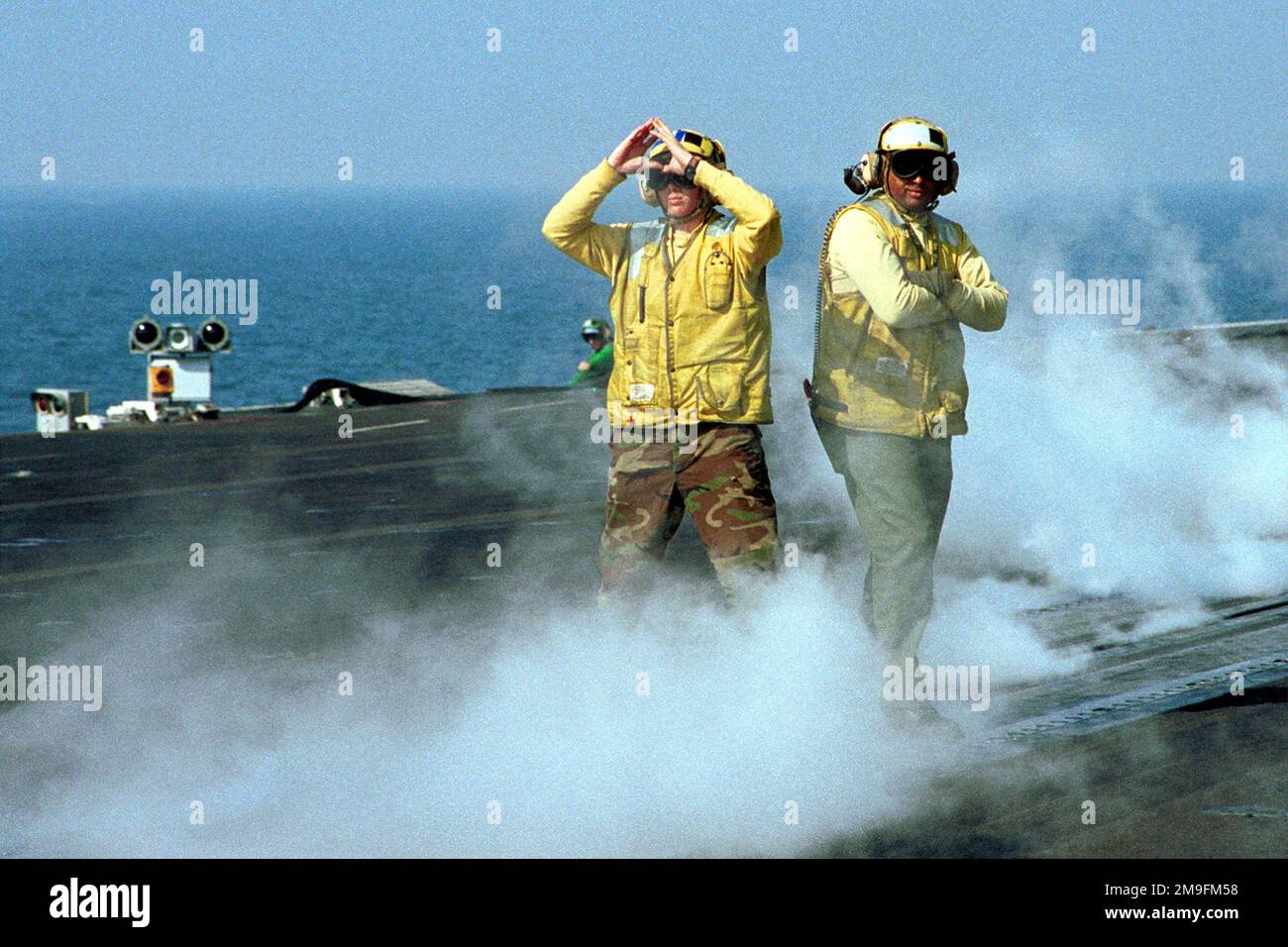 US Navy Aviation Boatswain's Mate AIRMAN (Handler) Ethan Lane directs ...