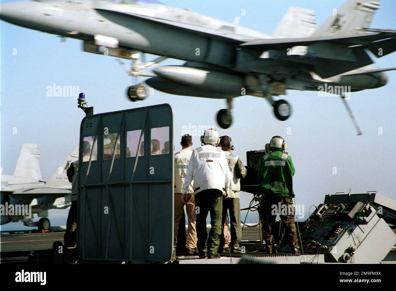 Landing Signal Officers on the LSO platform assist in another ...