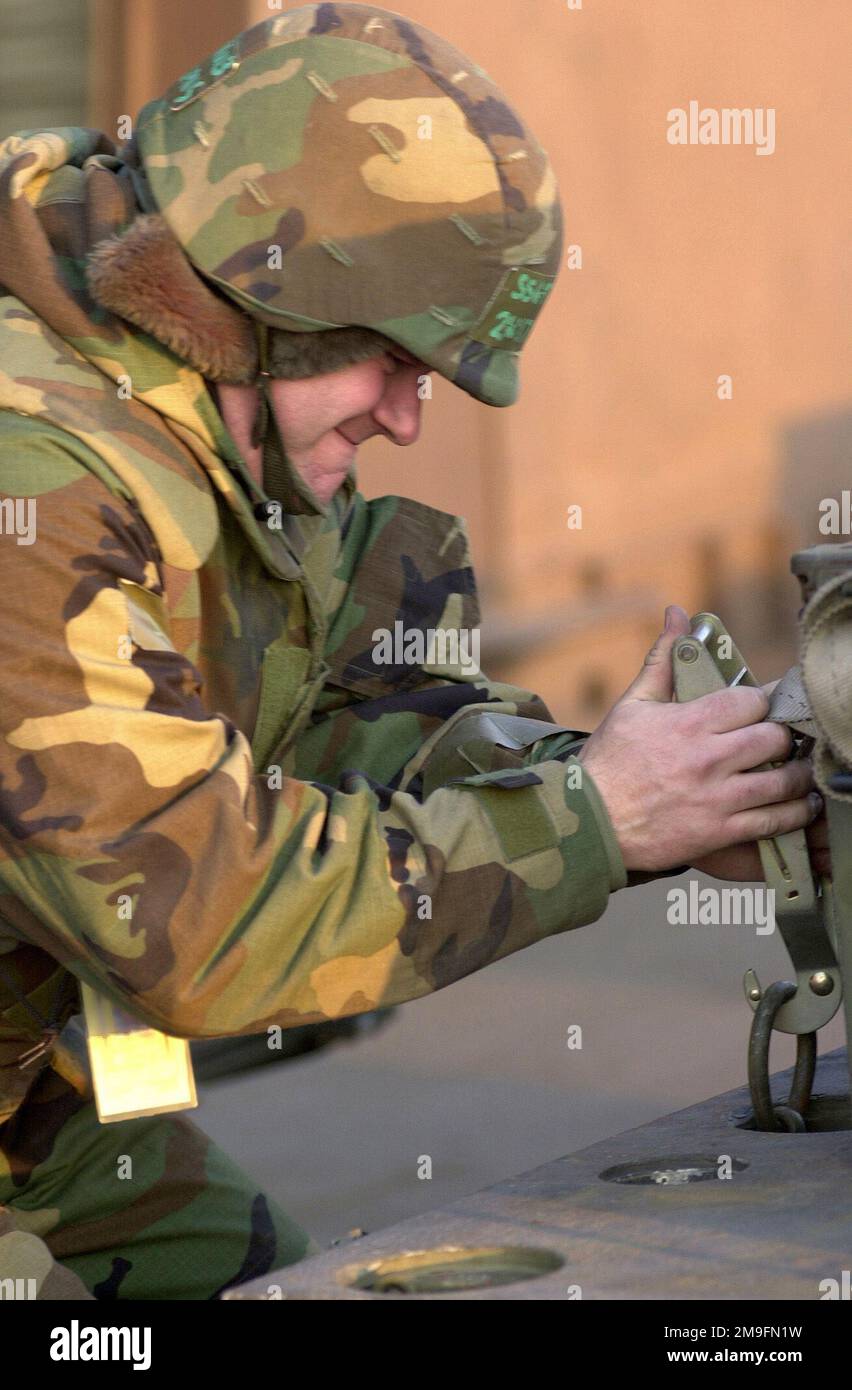 US Air Force STAFF Sergeant Mark Staub struggles to loosen a tie-down ...