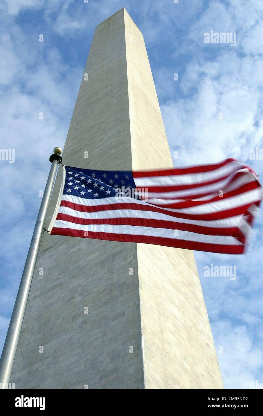 The Washington Monument serves as a backdrop for an American flag. Base ...
