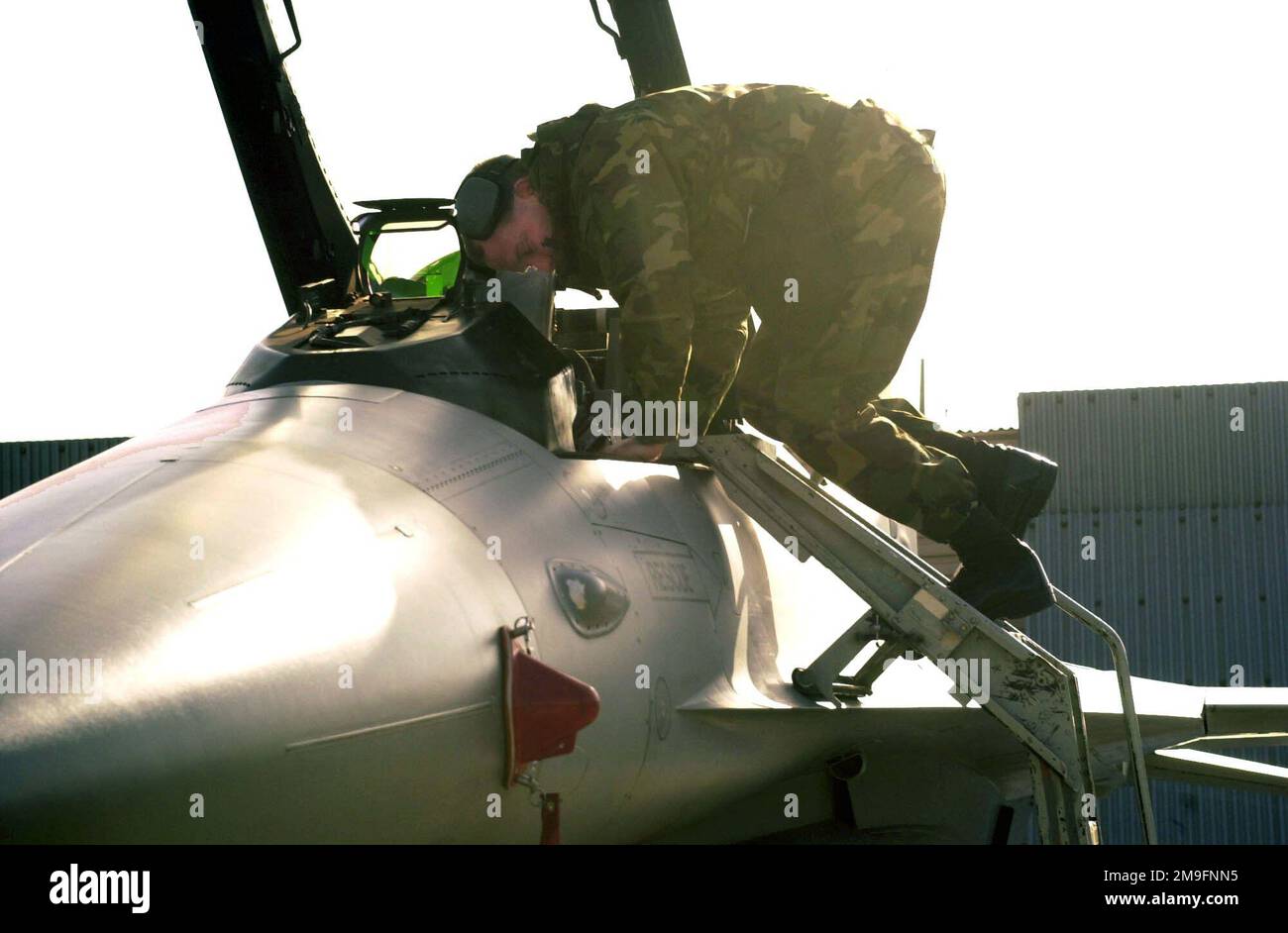US Air Force SENIOR AIRMAN James Prices checks the cockpit of his F-16 Fighting Falcon aircraft ...