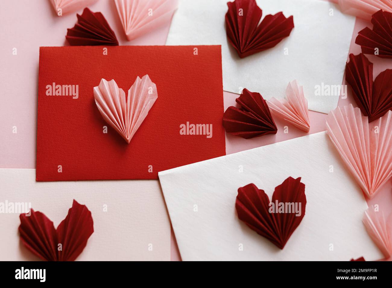 Valentines day flat lay. Stylish envelopes with pink and red hearts ...