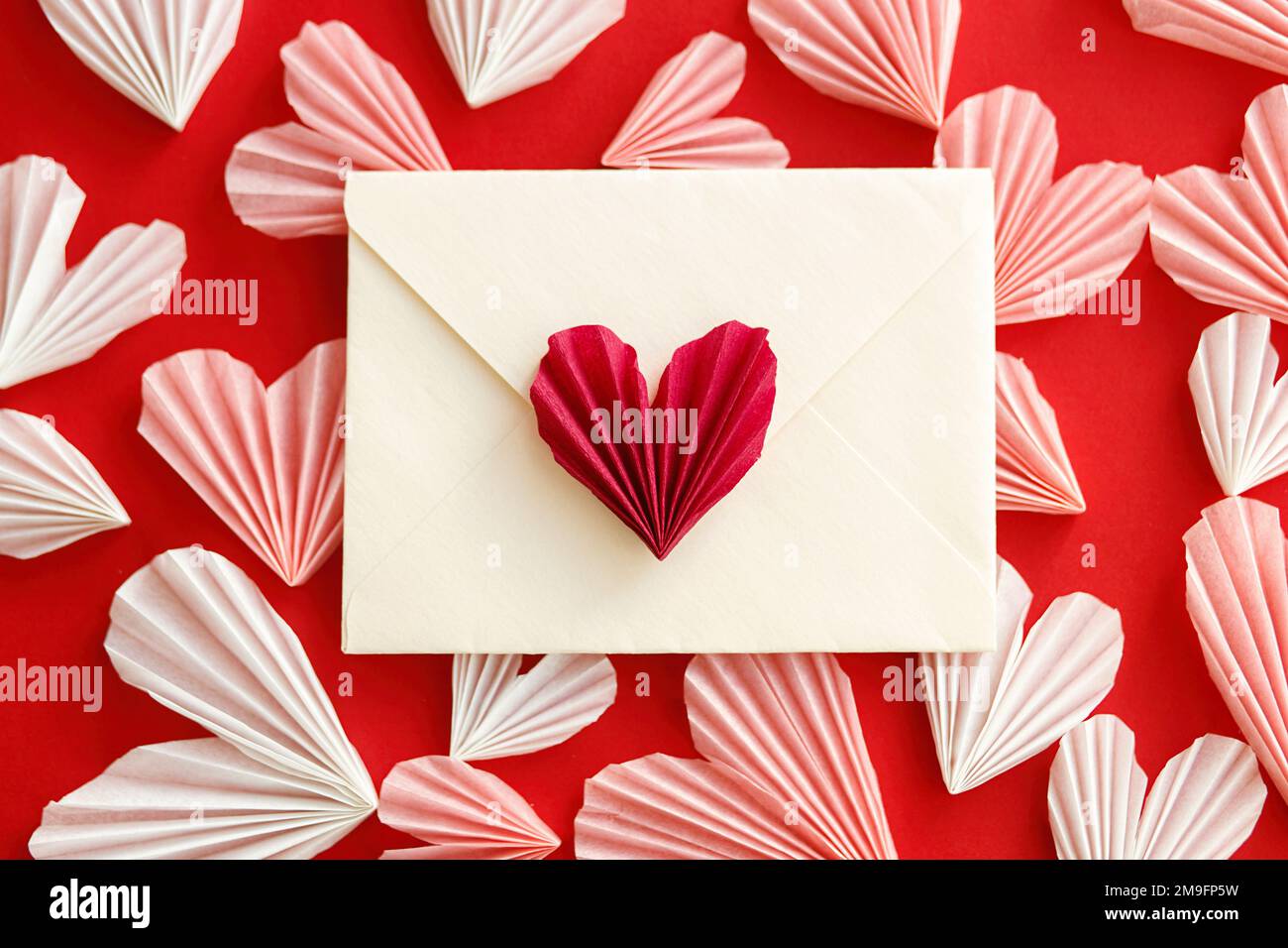 Valentines day flat lay. Stylish envelope with pink and red hearts ...