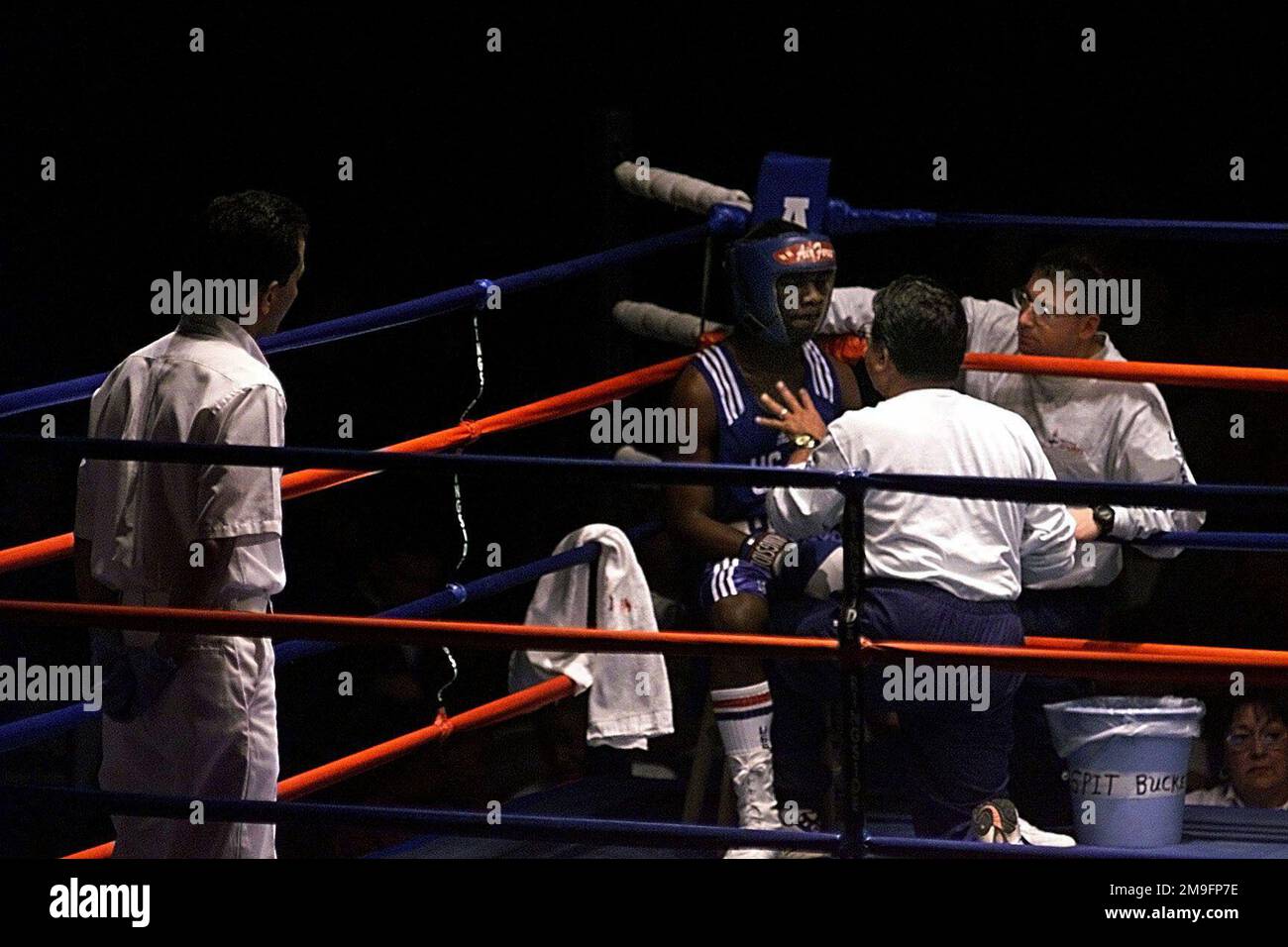 US Air Force boxer John Askew (In blue) receives instruction from his ...
