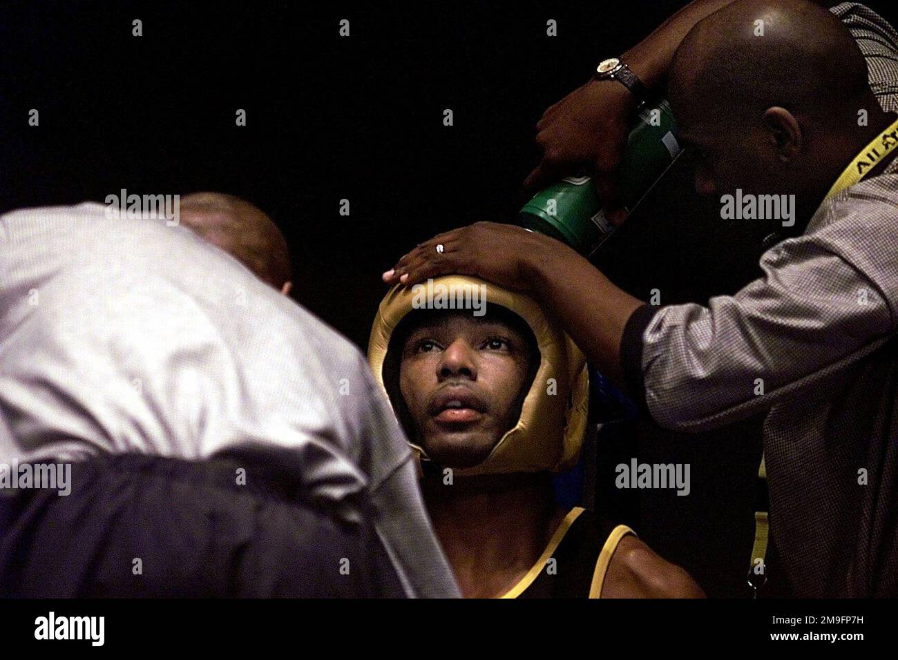 US Army boxer Julius Fogle (Center) receives instruction and gets cooled off with a water bottle ...
