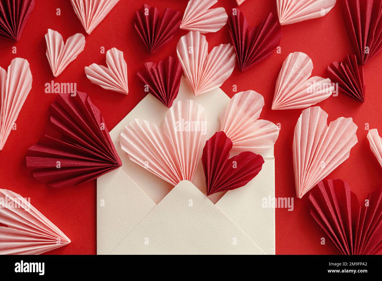 Valentines day flat lay. Stylish envelope with pink and red hearts ...