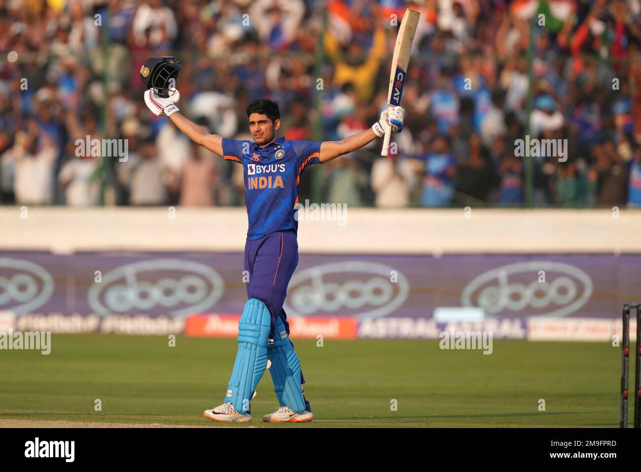 India's Shubhman Gill raises his bat and helmet to celebrate scoring a ...
