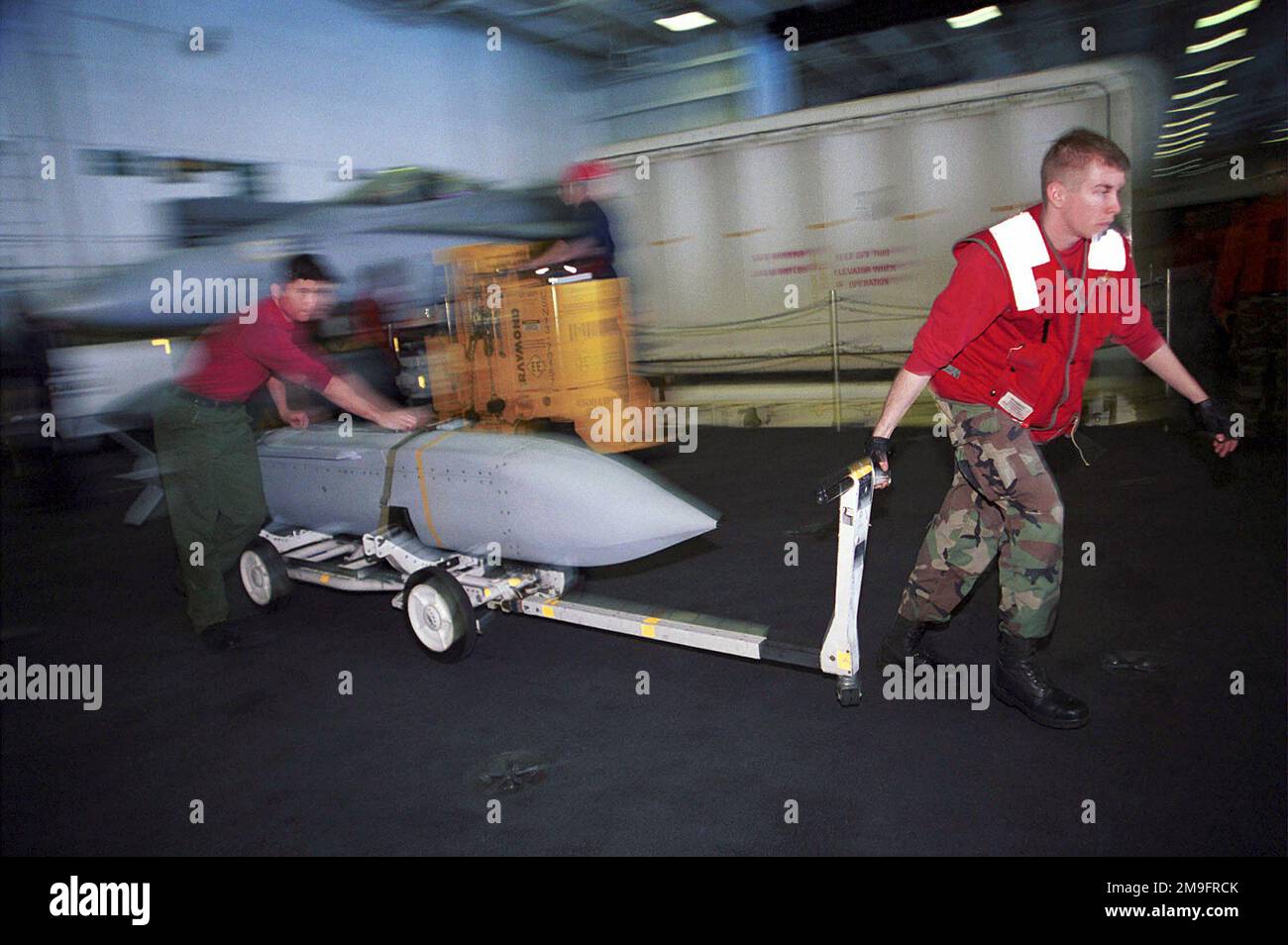 Aviation Ordnanceman AIRMAN Denver Foster moves a AGM-154A cluster bomb ...