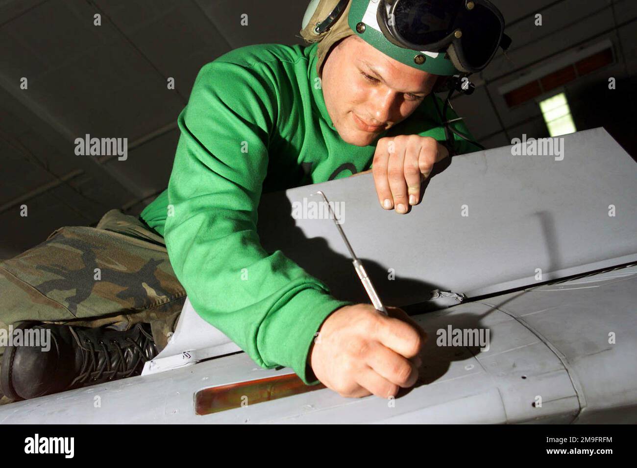 Aviation Electrician's Mate Third Class Joseph Manzella scales paint ...