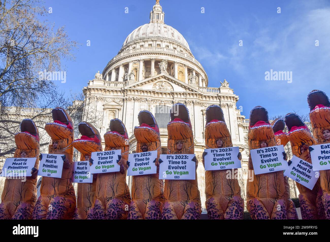 London, UK. 18th January 2023. PETA activists wearing dinosaur costumes urge people to go vegan ...