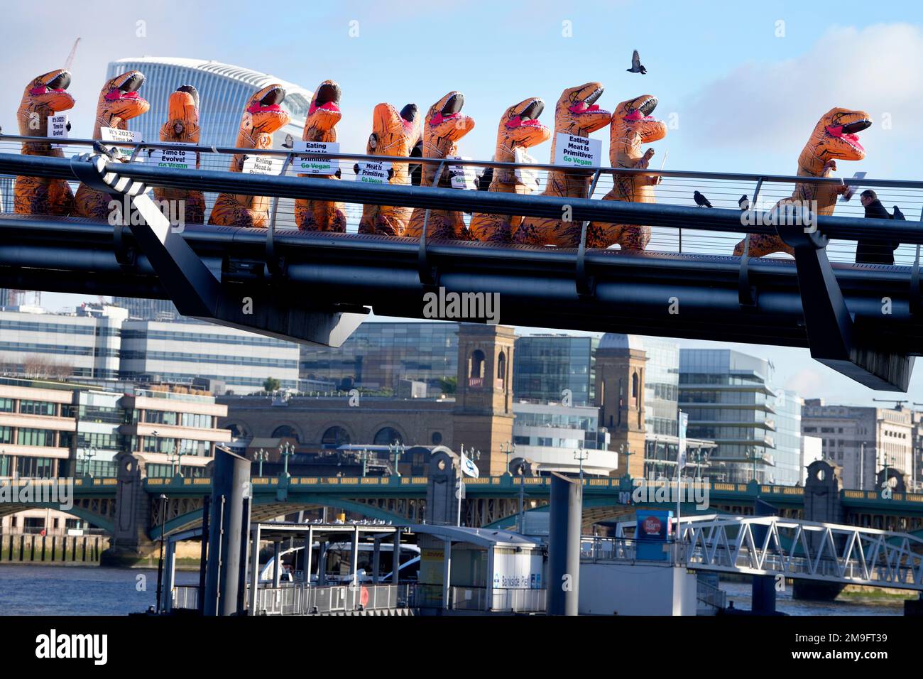PETA (People for the Ethical Treatment of Animals) supporters dressed in dinosaur costumes with ...