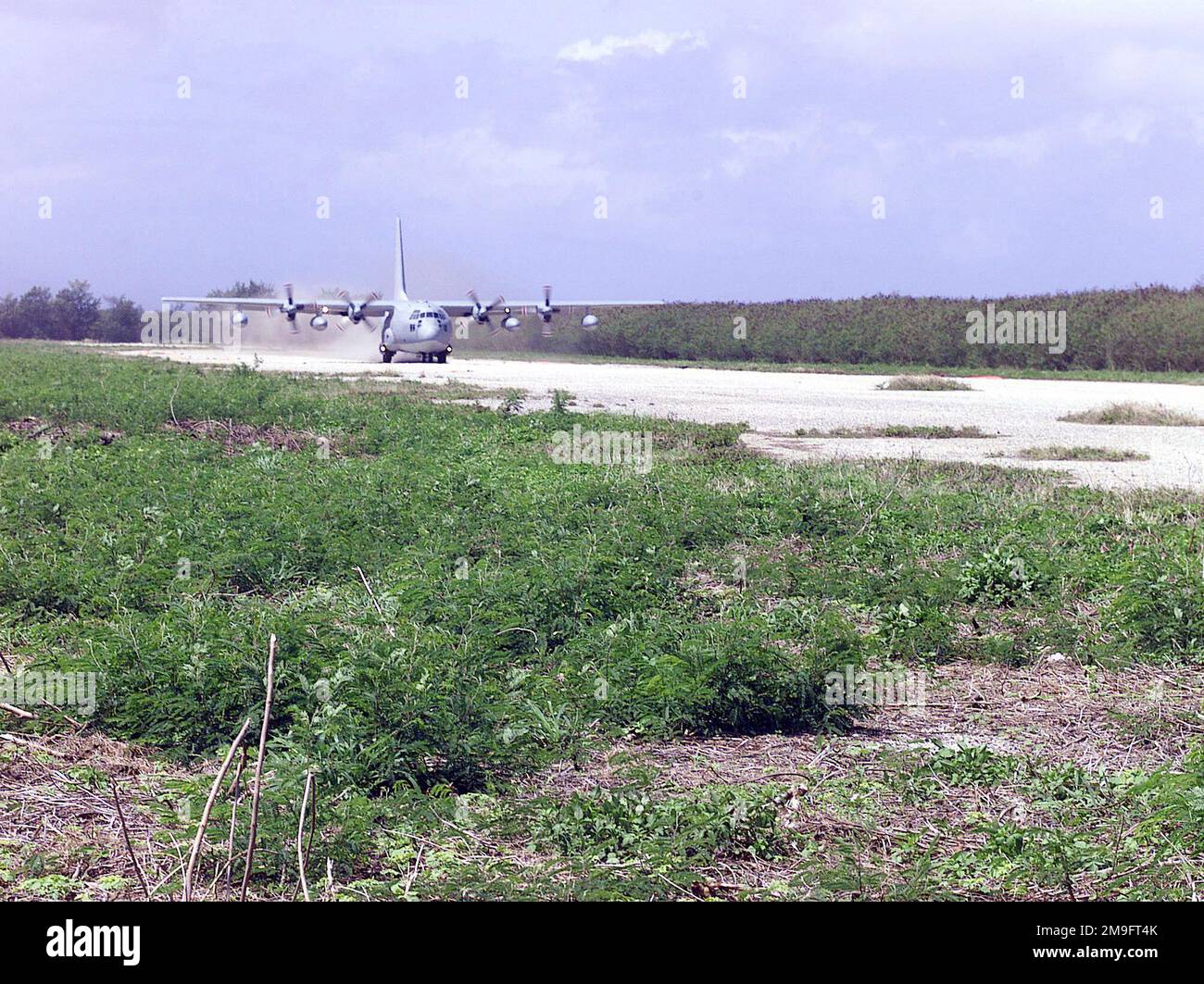 A C-130 Hercules aircraft heads down the runway for takeoff on Tinian ...