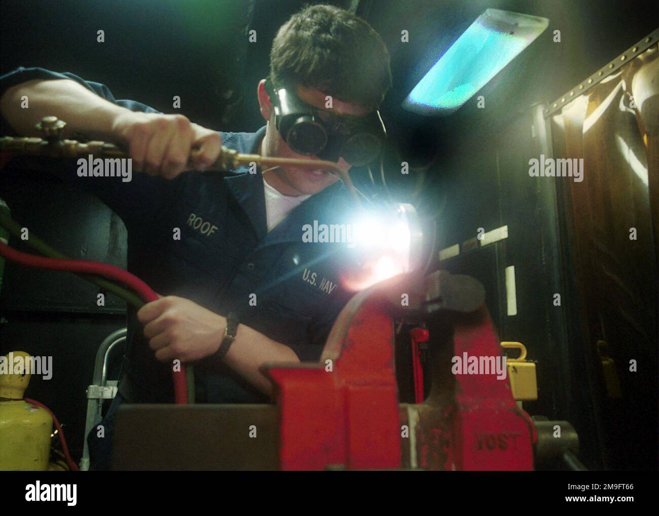 US Navy Hull Technician Fireman Jon Roof welds an Aqueous Firefighting ...