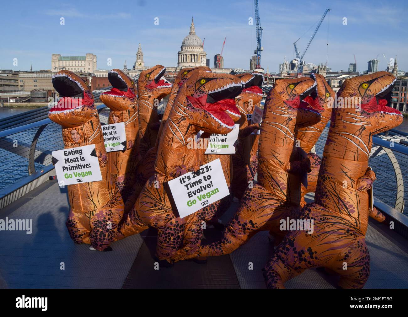London, UK. 18th January 2023. PETA activists wearing dinosaur costumes urge people to go vegan ...