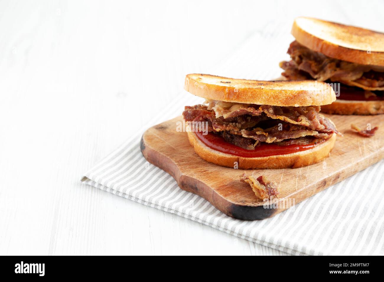 Homemade British Bacon Sandwich on a rustic wooden board, side view ...