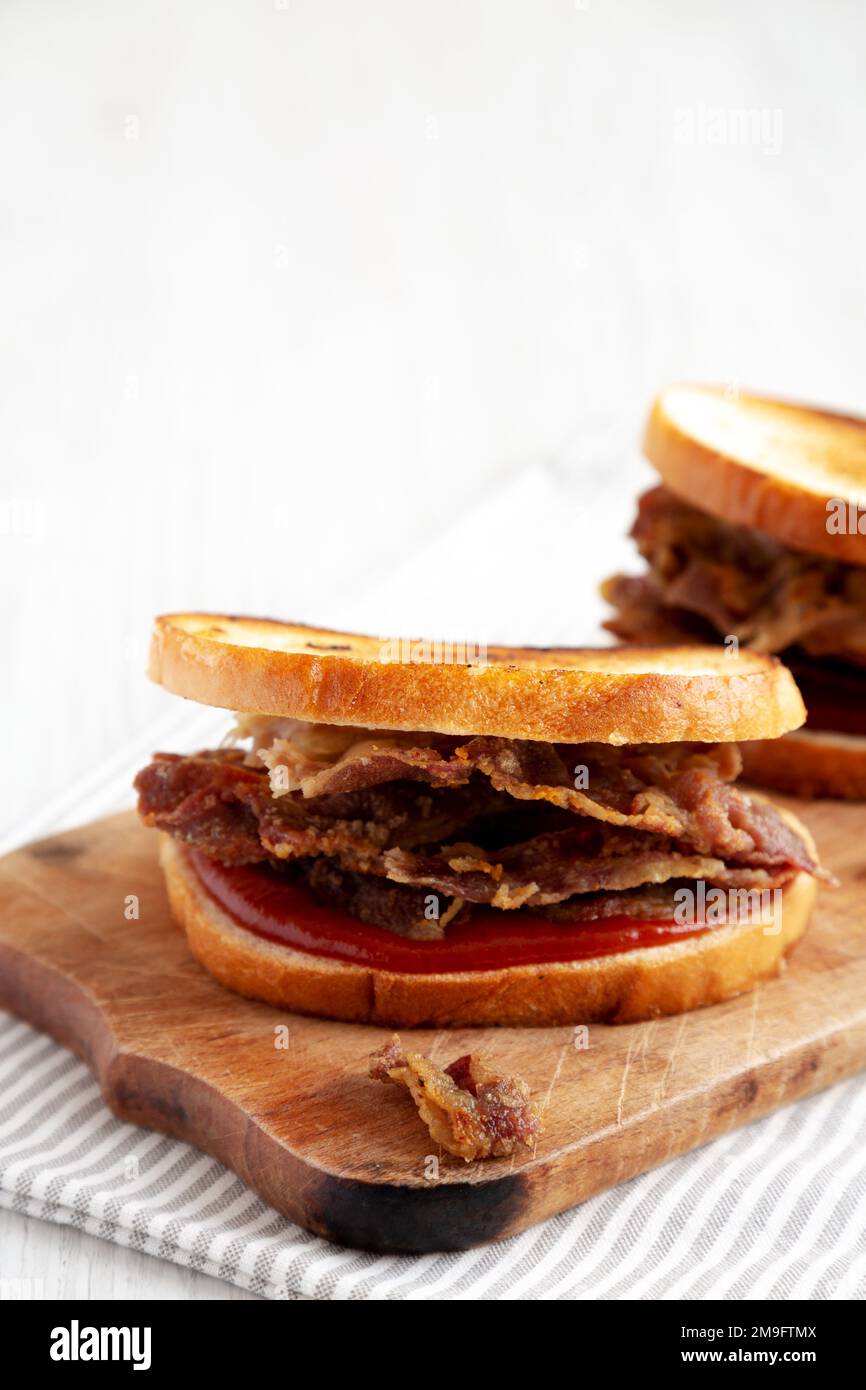 Homemade British Bacon Sandwich on a rustic wooden board, side view ...