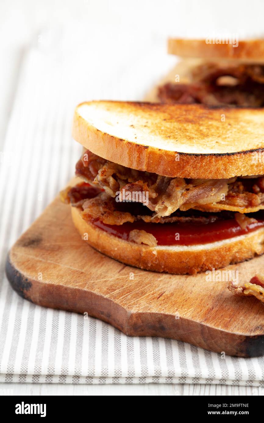 Homemade British Bacon Sandwich on a rustic wooden board, side view ...