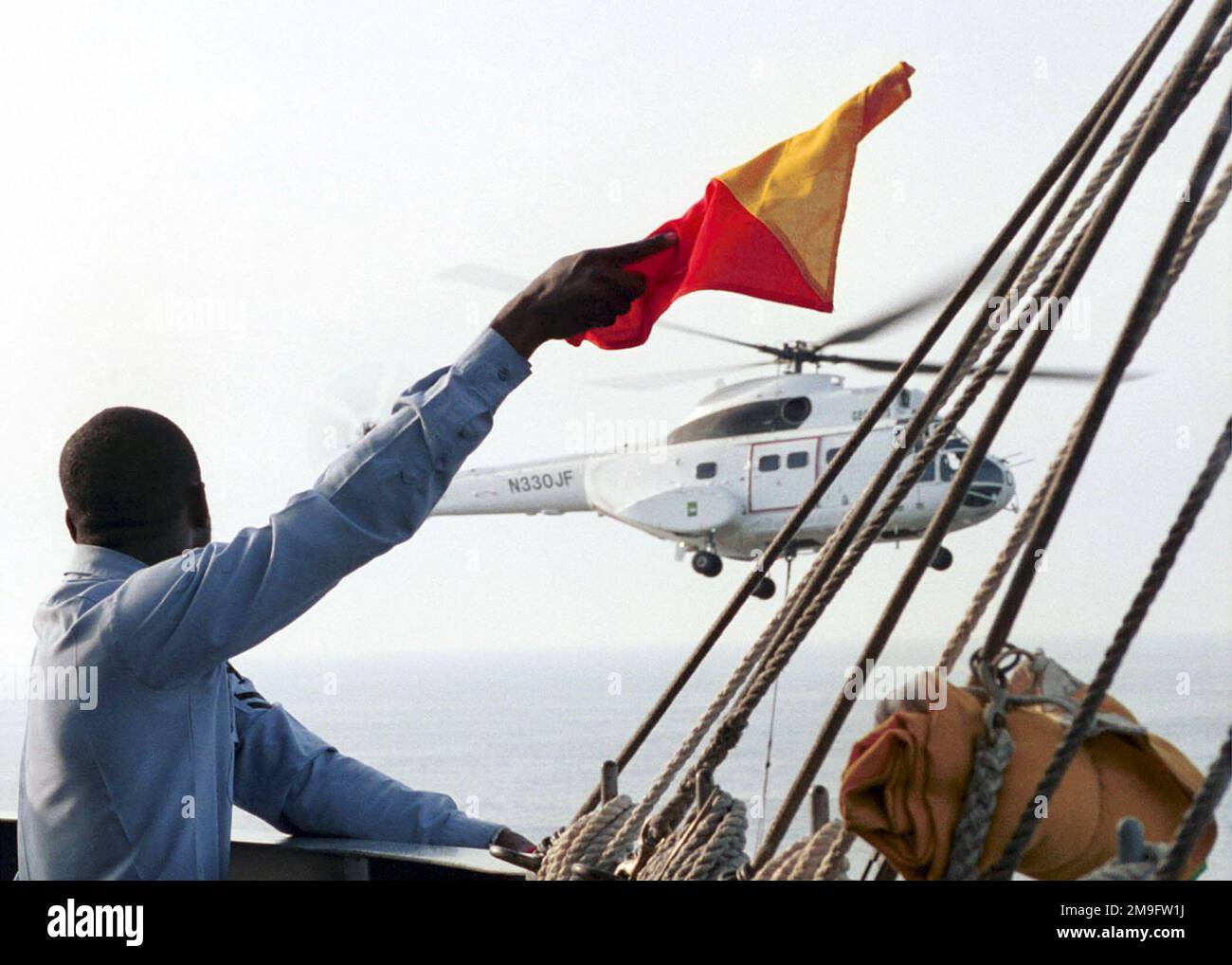 Signalman Second Class Kevin Lewis uses flags to signal messages to US ...