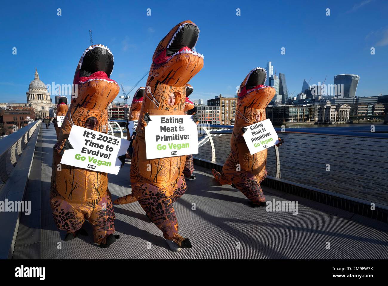PETA (People for the Ethical Treatment of Animals) supporters dressed in dinosaur costumes with ...