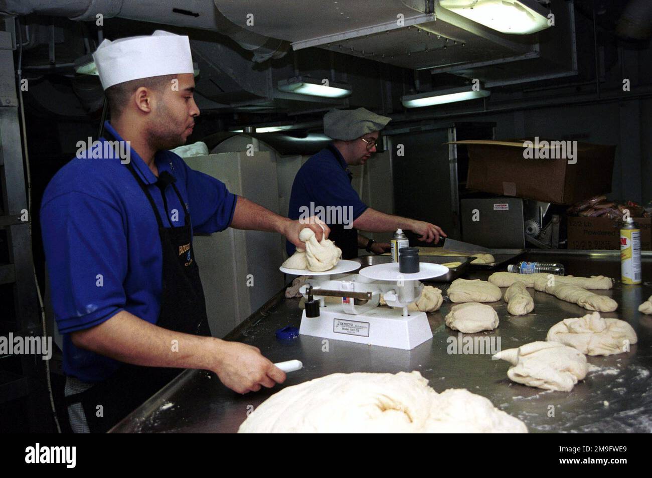 Mess SPECIALIST 3rd Class Obie Sorrella (Left) uses a scale to weigh ...