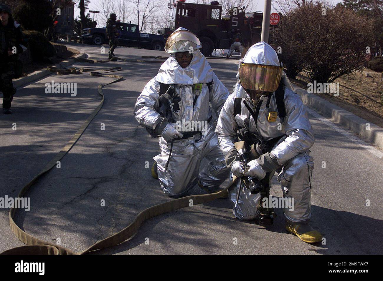 Dressed in firefighting gear, US Air Force SENIOR AIRMAN Brent Watkins ...