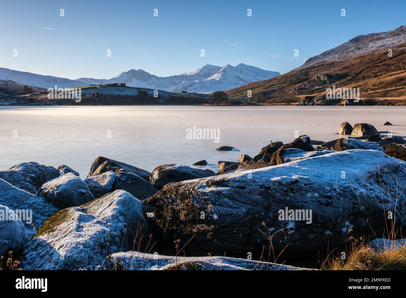 View of the Snowdon Horseshoe mountains with a frozen lake in the ...